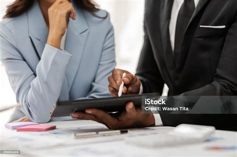 디지털 태블릿에서 작업하고 재무 수치를 분석하는 비즈니스 동료 디지털 태블릿에 대한 분석 비즈니스 재무 보고서 회의 회의 기업의 성공적인 결과를 보여줍니다 2명에 대한 스톡