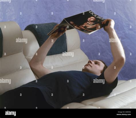 Man Lying On A Sofa And Reading Magazine Stock Photo Alamy