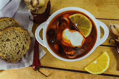 Solyanka 그릇 근접 촬영 수평 평면도에 러시아 고기 수프 접시에 미네스트로네 수프 고기 소시지 올리브를 곁들인 솔얀카 오래 된 나무 테이블에 고기 수프