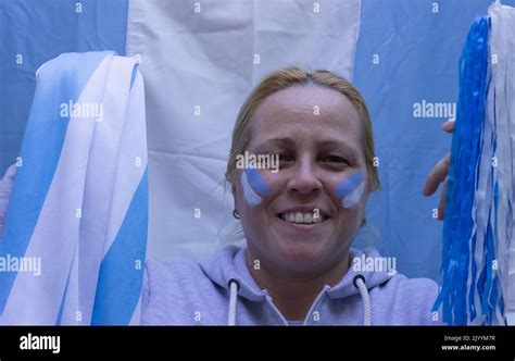 Blonde Woman With A Flag And Face Painted In The Colors Of Argentina