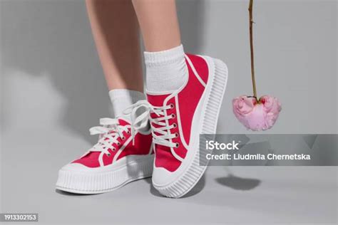 밝은 회색 배경에 아름 다운 꽃과 함께 빨간 클래식 올드 스쿨 운동화에서 포즈를 취하는 여자 근접 촬영 여자에 대한 스톡 사진 및 기타 이미지 Istock