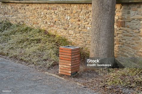 그늘진 나무 꼭대기 아래에는 사암 벽에서 나온 공원 베이지색 노란 모래 길이 있습니다 다년생꽃이 피고 정원 방문객을위한 몇 가지 현대적인 벤치가 있으며 광장의 밑바닥은