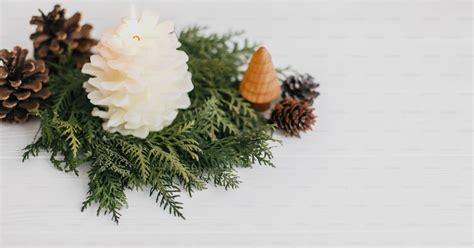 크리스마스 솔방울 촛불과 나무는 하얀 나무에 소박한 크리스마스 화환을 가지고 있다 작은 소나무와 백향목과 솔방울의 현대 화환