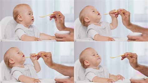 婴儿在白色高高的婴儿椅上的特写镜头，父亲用勺子和碗在父亲的手，当他喂养婴儿时，他抓住父亲手中的勺子， 视频素材下载