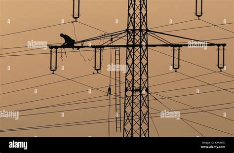 A Technician Works On The Power Lines Of A New Transmission Line At Lofty Heights Near