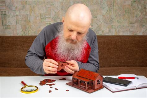 Bearded Man Architect Assembles A Small Model Of A Residential Building