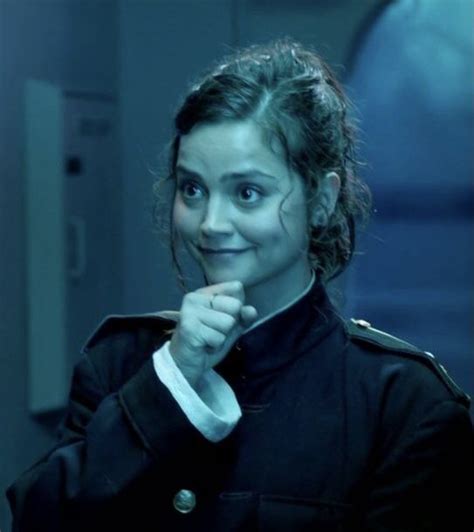 A Woman In Uniform Is Smiling And Looking At The Camera With Her Hand On Her Chin