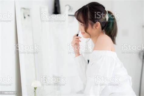 뷰티 초상화 젊은 아시아 여성은 침실에 브러시 뺨과 메이크업을 적용 얼굴을 찾고 거울 블러셔를 들고 여자의 아름다운 스킨 케어 및 화장품 개념으로 미소 가정 생활에 대한