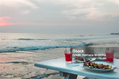 칵테일이 있는 테이블 바다에서 구운 음식 해변에서 낭만적 인 저녁 식사 발리 캉구 해변의 레스토랑과 일몰 바다 전망 0명에 대한