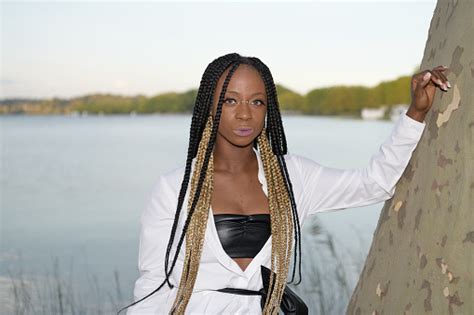 아프로 소녀 는 배경에 호수와 긴 검은 색과 금발머리띠와 카메라를보고 포즈 땋은 머리에 대한 스톡 사진 및 기타 이미지 땋은 머리 검정 머리 긴 Istock