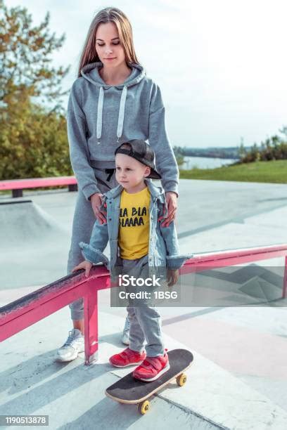 어린 어머니는 스케이트 보드를 타고 가르친다 어린 소년의 아들 여름 날 가을 옷 캐주얼 한 옷 육아에 도움과 지원 아이들을 돌보는 가을에 대한 스톡 사진 및 기타 이미지