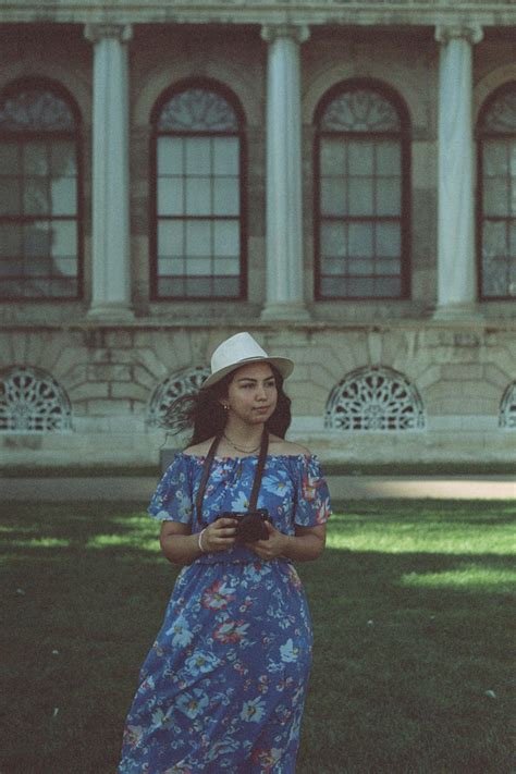 공원 관광 관광객 꽃 무늬 드레스 모자 서 있는 수직 쐈어 여름 여성 여행 젊은 여성 카메라 패션 사진에 관한 무료 스톡 사진