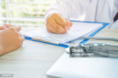 의료 의료 개념 남자 의사는 노트북 컴퓨터 근처 기록 정보 종이와 처방 클립 보드를 작성 의사의 사무실에서 처방전 약을 수신 환자를 듣고 2명에 대한 스톡 사진 및 기타