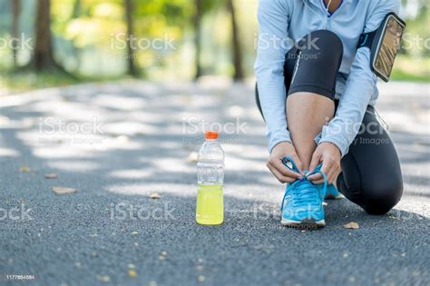 공원에서 운동화를 묶는 젊은 운동 선수 여성 외부 도로에서 조깅을 할 준비가된 여성 주자 아침에 는 아시아 피트니스 걷기 및 운동 웰빙 및 스포츠 컨셉 개념에 대한 스톡