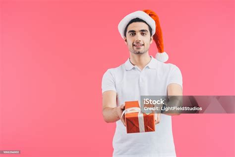 핑크 새 해에 고립 된 선물 상자를 주는 산타 모자에 잘생긴 남자를 웃 고 T Lounge에 대한 스톡 사진 및 기타