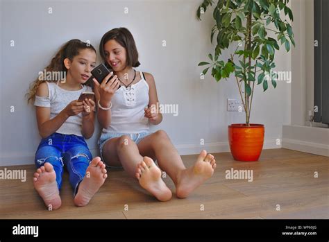 Preteen Girls Showing Each Other Content On Their Mobile Phones Stock