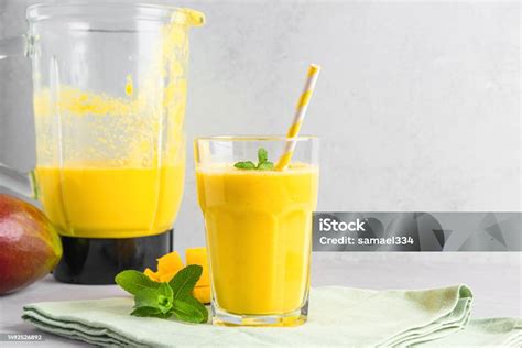 신선한 육즙이 많은 과일과 블렌더가 들어간 노란색 망고 스무디 한 잔과 건강한 여름 음료를 만들기위한 믹서기 라씨에 대한 스톡 사진 및 기타 이미지 Istock