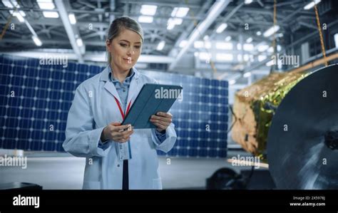 Female Engineer Uses Tablet Computer While Working On Satellite Construction Aerospace Agency