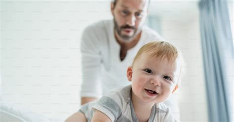 백인 부모는 집에서 침대에서 귀여운 남자 아이 유아와 놀고 있습니다 행복 한 가족 매력적인 잘 생긴 아빠는 행복으로 유아 아들을 크롤링 집에서 침실에서 활동을 기상 한