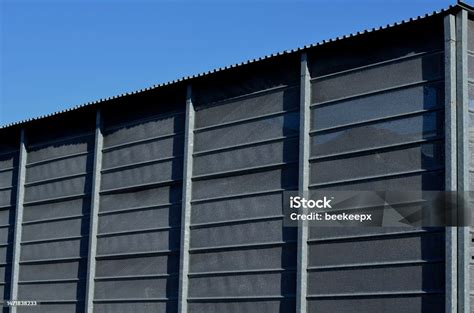 확장 된 금속 격자 구조를 가진 건물의 강철 클래딩 아연 도금 회색 그물은 산업 건물을 보호합니다 은색 배경과 대조되는 푸른