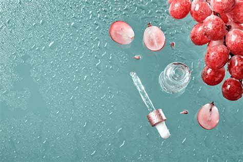 포도 씨 오일과 허브 성분을 함유한 유기농 화장품 제로 폐기물 와인 제조 블루 배경에 스킨케어 제품 병 포도 및 물 방울 포도에