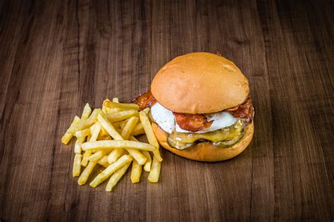 치즈 계란 베이컨 피클 감자 튀김을 나무 테이블과 소박한 배경에 얹은 수제 쇠고기 버거 고기에 대한 스톡 사진 및 기타 이미지 Istock