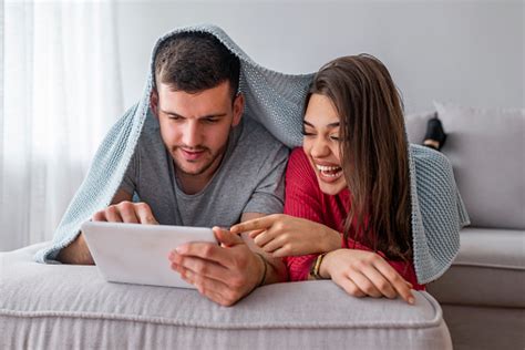 거실과 태블릿을 사용 하 여 집에서 담요 아래 소파에 편안한 귀여운 커플 2명에 대한 스톡 사진 및 기타 이미지 2명 가정 생활 게으름 Istock