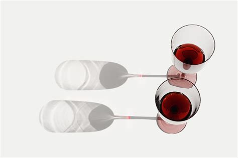 햇빛 그림자가 있는 드라이 레드 와인의 컬러 유리 잔이 있는 정물 여름 플랫 레이 최소한의 스타일 두 개의 와인 잔 흰색 배경에 알코올 음료 복사 공간 트렌드 미학 붉은