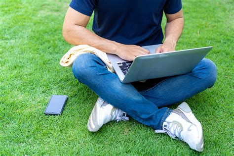 디지털 노트북으로 인터넷에서 정보를 검색하고 소셜 미디어 모바일 애플리케이션에서 채팅하고 공원에서 친구들과 온라인 게임을 즐기는 잘생긴 청년 노트북에 대한 스톡 사진 및