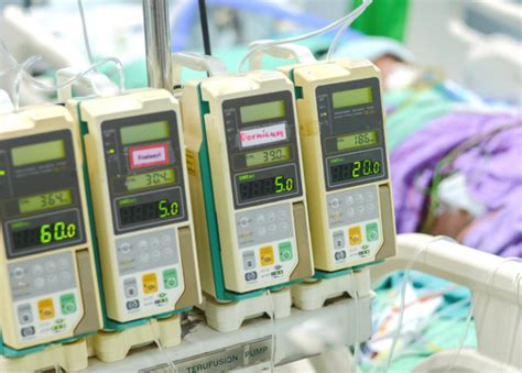 Photo Of 4 Medication Infusion Pumps Next To The Bed Of A Patient In