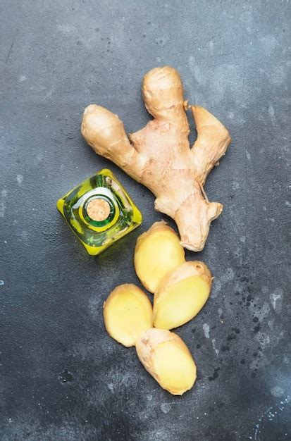 Premium Photo Ginger Oil And Fresh Ginger Root Gray Kitchen Table