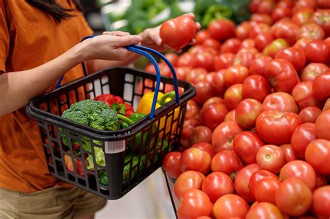 식료품점에서 신선한 유기농 과일과 채소를 쇼핑하는 쇼핑 바구니를 들고 있는 젊은 여성의 자른 사진 농수산물 코너에 대한 스톡 사진 및 기타 이미지 Istock
