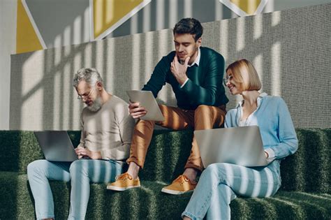 창의적인 공간에서 함께 일하면서 기술을 사용하는 자신감있는 비즈니스 사람들 3 명에 대한 스톡 사진 및 기타 이미지 3 명