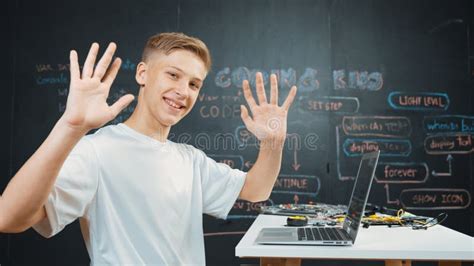 Side View Of Young Boy Programing Code While Looking At Camera