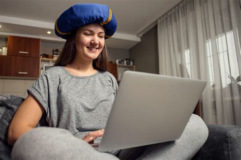 젊은 여성이 노트북과 소셜 네트워크에서 통신 노트북 그녀의 머리에 소라와 여자의 자에 집에 앉아 여자 해외 친구 들과 채팅 개념에 대한 스톡 사진 및 기타 이미지 Istock