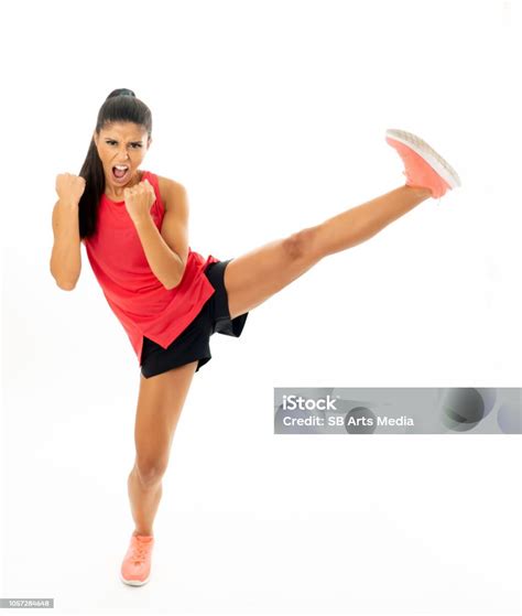 싸움에 킥 복싱 훈련 운동 던지는 적극적인 젊고 분노 라틴 여자 킥 공격 피트 니스 스포츠 체육관 운동 및 개인 방어 개념에 흰색 배경에 고립 건강한 생활방식에 대한 스톡