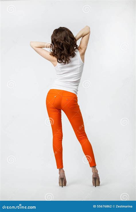 Rear View Portrait Of Young Woman Posing On Neutral Background Stock