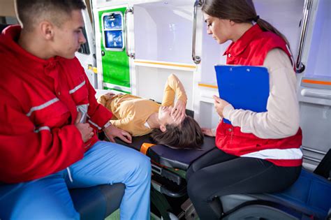 구급차에서 들것에 누워 있는 젊은 여성 의사와 구급대원이 응급 처치를 하고 있다 20 24세에 대한 스톡 사진 및 기타 이미지 20 24세 25 29세 3 명