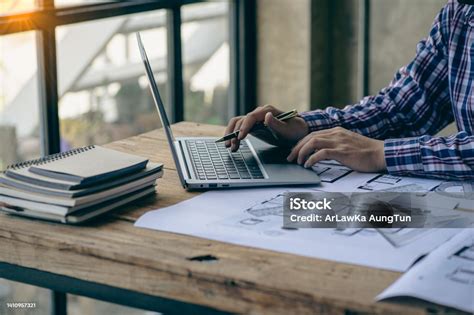 건설 현장의 청사진에서 건축가를 스케치하는 프로젝트에서 일하는 한 남자의 클로즈업 건축가 책상 건설 프로젝트 배너의 엔지니어 개념 건축가 장비를 사용한 도면 계획 마무리