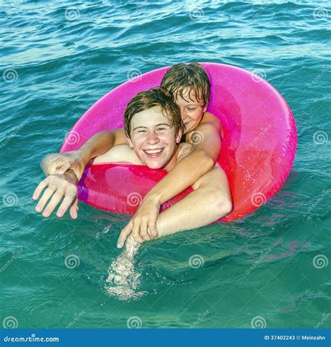 Deux Garçons Dans Un Tube De Natation Ont Lamusement Dans Locéan
