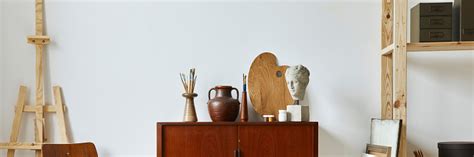 디자인 복고풍 티크 컴모드 의자 책장 포스터 프레임 이젤 장식 및 우아한 개인 액세서리와 아티스트 작업 공간의 세련된 구성