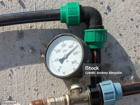 압력 게이지는 콘크리트에 장착된 배관 파이프와 녹색 커플링으로 물 시스템 압력을 보여줍니다 0명에 대한 스톡 사진 및 기타