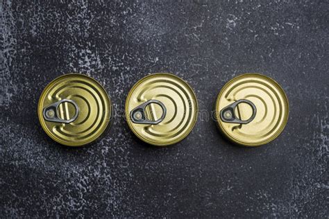 A Trio Of Small Circular Ring Closed Tins That Are Easy To Open On A Gray Surface Stock Image