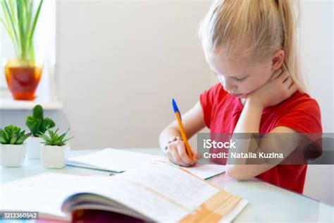 세리오스 금발 여학생 앉아 집에서 학교 숙제를 하 고 노트북에 쓰기 테이블에 교육 책 학교로 돌아갑니다 원격 학습 온라인 교육 가상현실에 대한 스톡 사진 및 기타 이미지