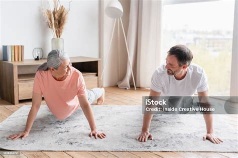 실내에서 판자 위치에 서 강한 건강 한 부부 피트 니스 운동을 하 고 스트레칭 몸에 맞는 유지 완벽 한 모양 활동적인 노인 거리가 먼에 대한 스톡 사진 및 기타 이미지