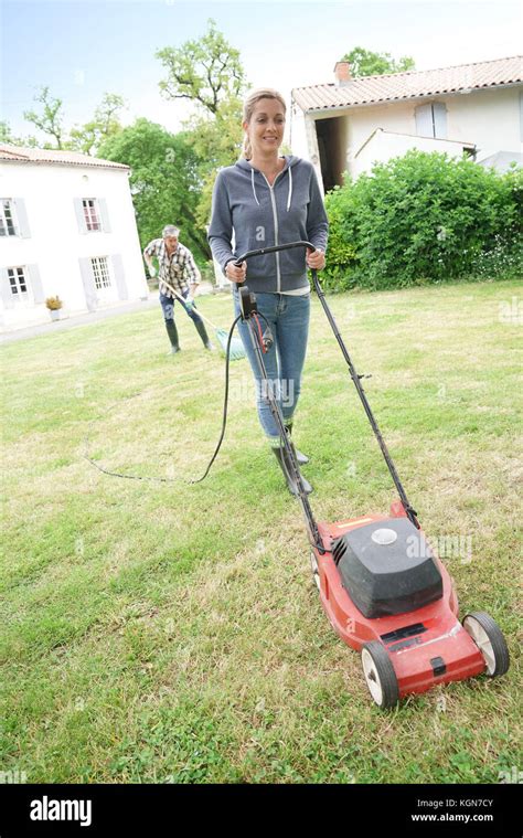 Woman In Garden Mowing The Lawn Stock Photo Alamy