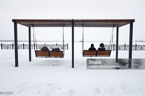 겨울에는 얼어붙은 강 맞은편 제방에 있는 사람들이 그네를 휘두르고 있습니다 겨울 주말 컨셉 12월에 대한 스톡 사진 및 기타 이미지 Istock