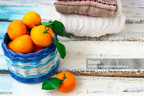 귤 계피 스틱 소나무 콘이 있는 크리스마스 바구니는 나무 흰색 배경에 놓여 있습니다 니트 점퍼는 서로의 위에 쌓여 화환이 아름답게 타납니다 Hygge 컨셉 0명에 대한 스톡