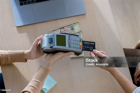 접수 원에게 지불에 신용 카드를 사용하는 고객님 무현금 기술 및 신용 카드 결제 개념 고객이 신용 카드를 사용하여 지불하는 소매점의 소유자 2명에 대한 스톡 사진 및 기타