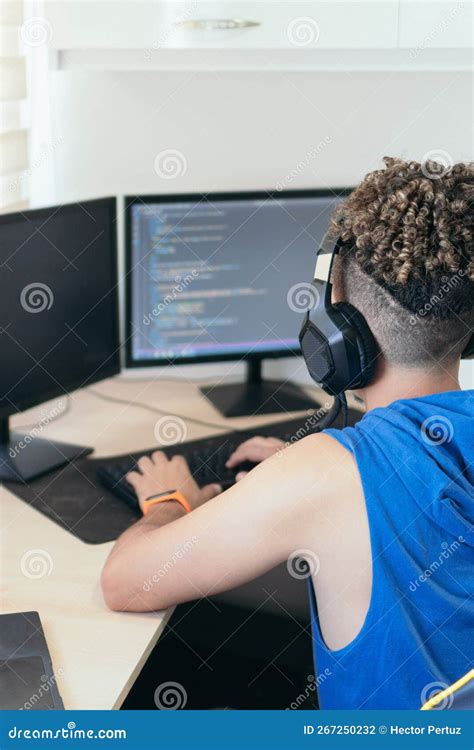 Computer Programmer Sitting At Desk And Typing On Computer Keyboard While Creating Code While